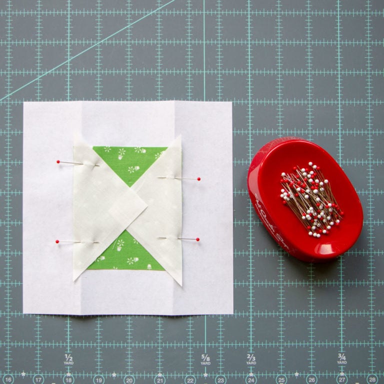 After trimming, pin the next two fabric pieces to the center square.