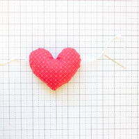 Leave about 2″ of space between hearts and 20″ of yarn on either end of ...